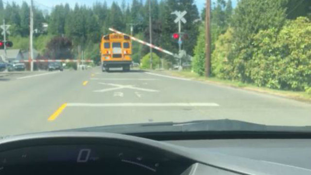 School bus hit by railroad crossing arm, drives over tracks ahead of ...